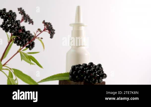 Nasal spray with a black berry on a white background, homeopathic ...