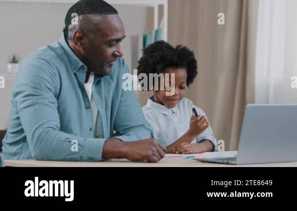 Caring african american father helping little daughter schoolgirl do ...