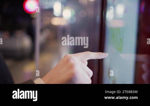 A mans hand selects fast food on an electronic touch screen in a street ...