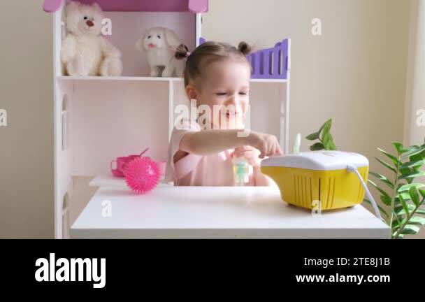Girl turns on the inhaler button and breathes steam with the medicine ...