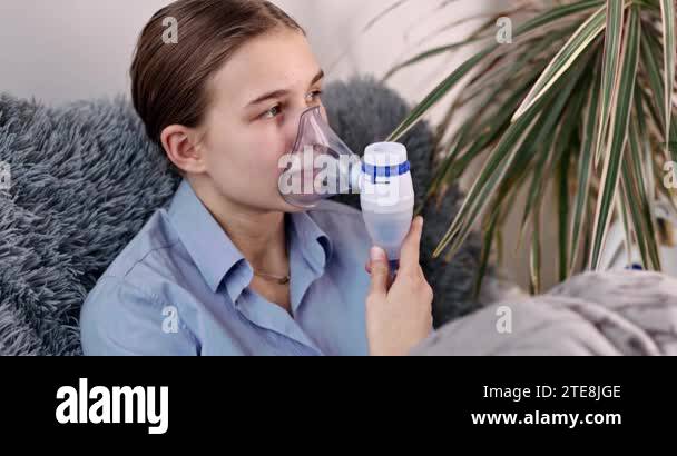 Teenage girl makes inhalation with a nebulizer equipment. Sick child ...