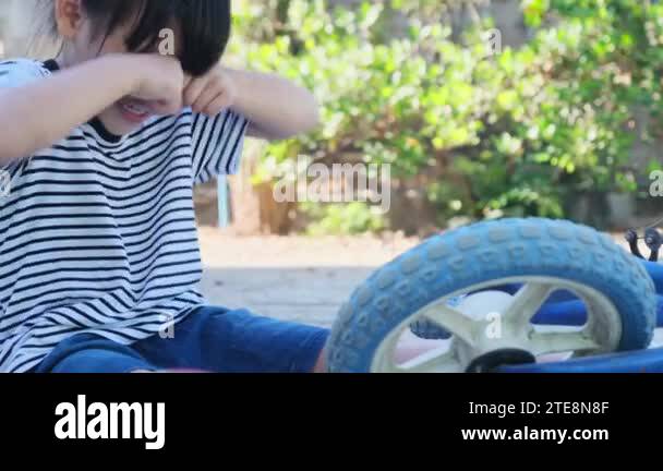 Sad little girl sitting on the ground after falling off her bike at ...