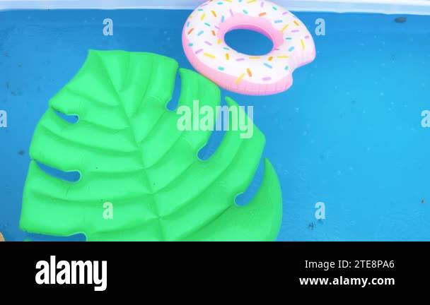 TOP DOWN: Rain begins pouring down on inflatable leaf and donut ...