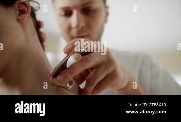 Fascia release soft tissue treatment on her neck with stainless steel ...