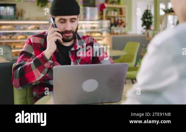 In front of the camera attractive guy with laptop Woking concentrated ...