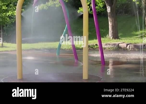 Fountain with splashing water in a public park without people in summer ...