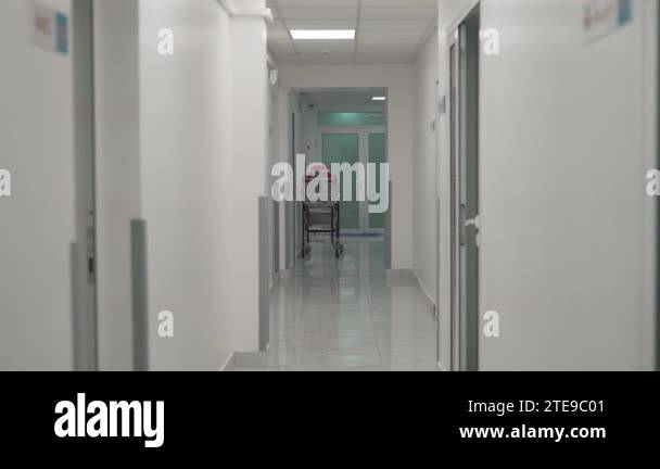 Empty hospital bed in the corridor of an empty modern clinic. Stretcher ...