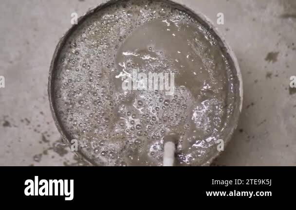 Mixing Building Cement Glue or Mortar with Water in a Bucket Using ...