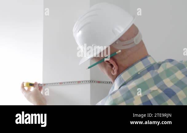 Engineer Working in a Construction Site, Using a Tape Measure for ...