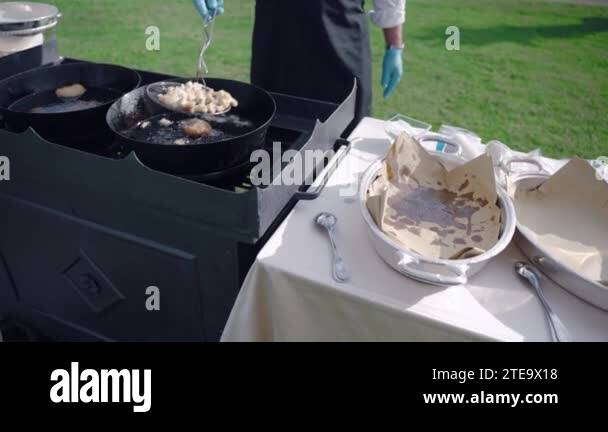 Professional restaurant chef preparing outdoors banquet table with ...