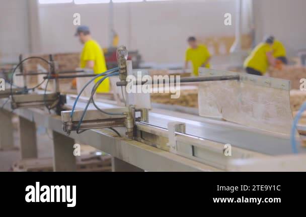 Workers sort out wooden blocks at a furniture factory. Workers on the ...