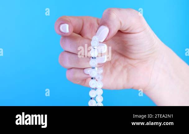 Woman lit hand counts mala beads strands of gemstones used for keeping ...
