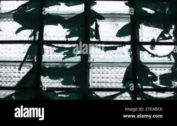 Metal bars on the window of an old industrial building. Dirty window of ...