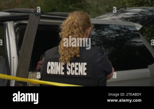 A crime scene investigator walks around and takes pictures of a crime ...