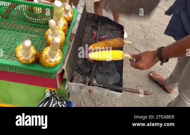 Delicious street food on a beach. Man waving fan and turning around ...
