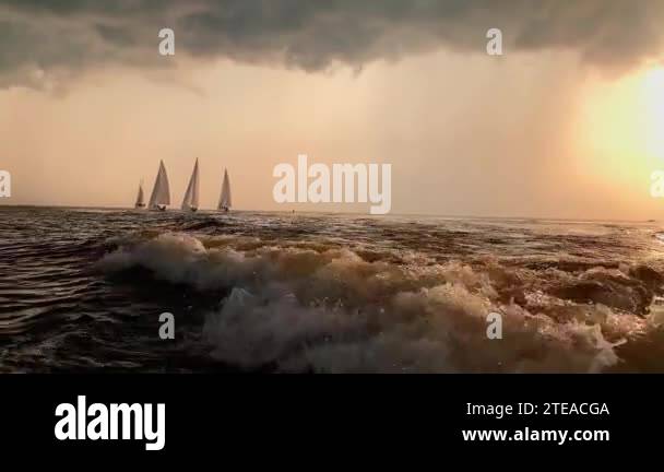 A few sailboats in a sea at sunset, magic sun reflection, sun path, the ...