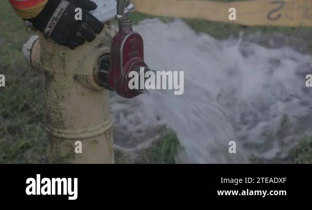 Firefighter drains water out of a fire hydrant during emergency ...