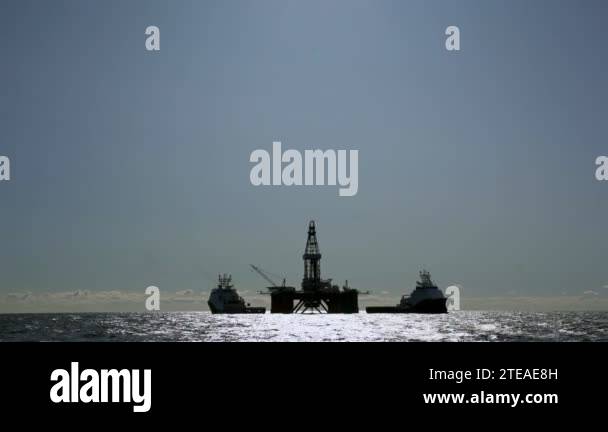 Offshore drilling platform. Vessels around RIG. Crane RIG lowers cargo ...