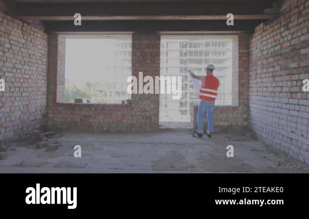 Engineers with a blueprint inside a new house. Builders inside a new ...