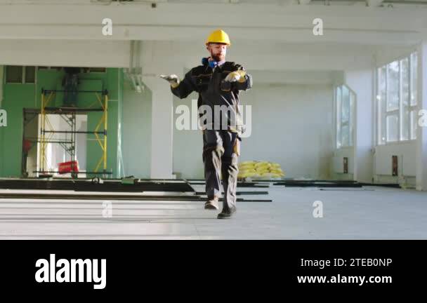 Charismatic and good dancing engineer man at construction site at the ...