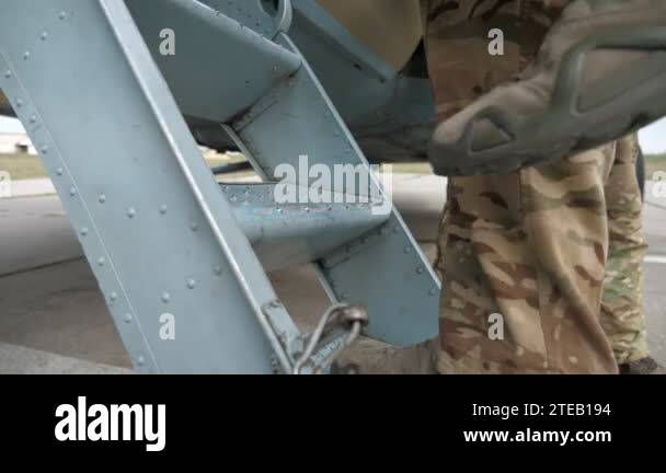 Military soldiers climbing ladder to enter a modern helicopter on a big ...