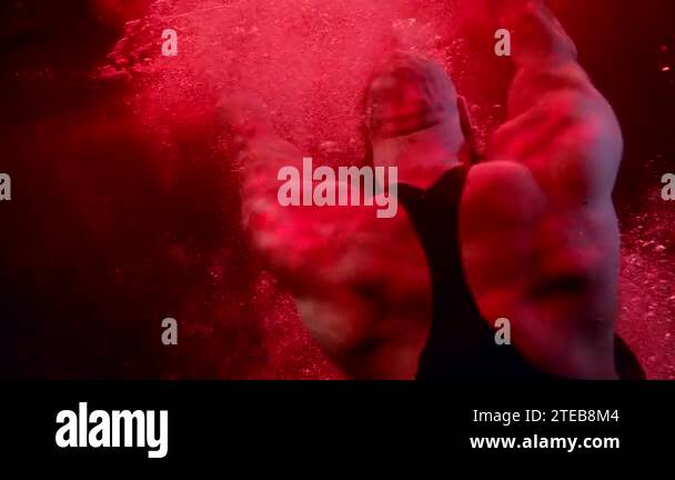 angry bodybuilder is diving in pool and showing his muscles, rear view ...