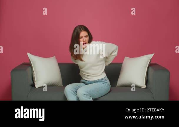 Back pain. Young girl suffering backache, pinched nerve, touches lower ...