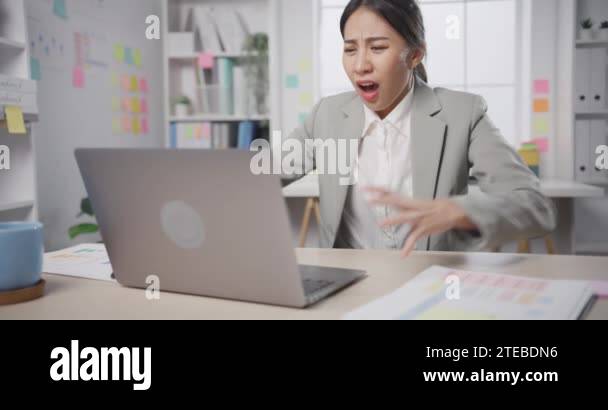 Young Asia businesswoman sitting on desk crazy with overworked stress ...