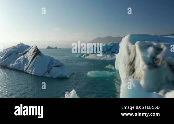 Ice floes floating in arctic water. Forwards fly above large lake ...