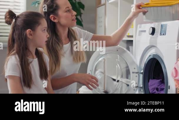 Performing clothes wash in a washing machine step by step. Woman shows ...
