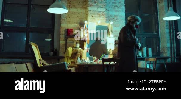 Clown with red nose and makeup standing up, saying goodbye to his ...