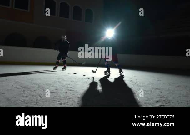 Two men hockey player in uniforms masterfully dribbles, hitting puck ...