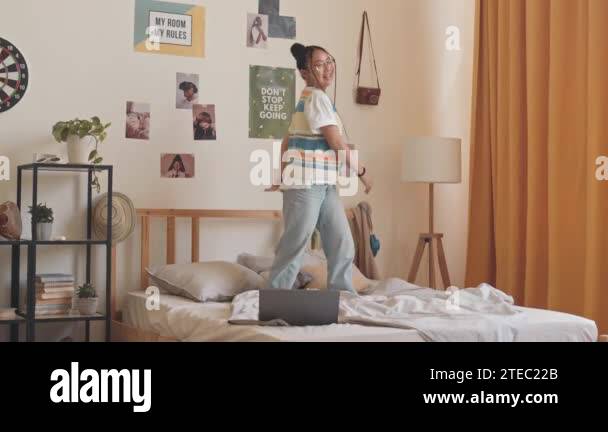 Full-length shot of gen z Asian teenage girl in knitted vest and blue ...