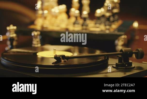 Close-up vinyl disk playing on turntable with male Caucasian hand ...