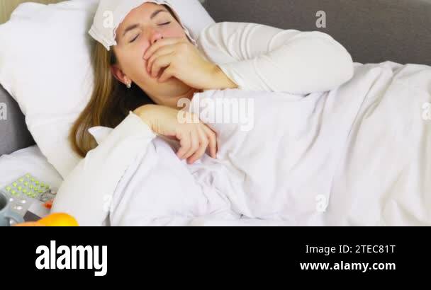 Sick Young Woman Sick With Severe Cough Lying In Bed Under The Blanket