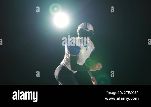 American football player wearing uniform, pads and helmet catches pass ...