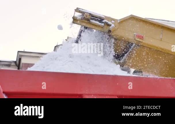 Snow cleaning tractor, claw loader vehicle loading pile of snow on a ...