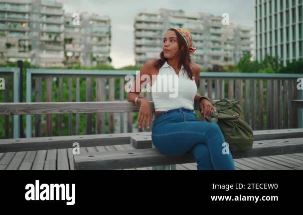 Cute tanned woman with long brown hair wearing white top and yellow ...