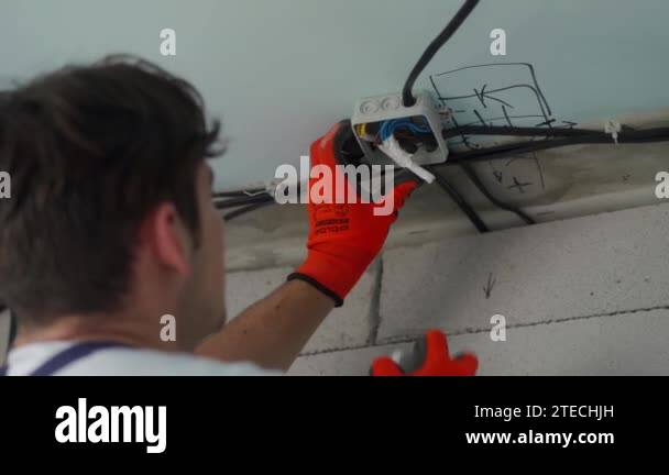 Electrician mounting junction box, instaling electrical wiring in ...