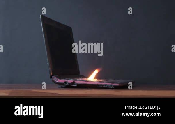 In the room on the table, a laptop caught fire, flames and sparks, a ...