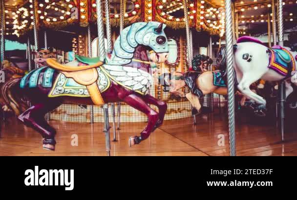 Old French carousel in a holiday park. Three horses and airplane on a traditional fairground ...
