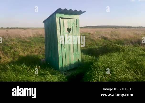 Old wooden toilet with a carved window with the shape of a heart cut ...