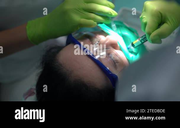 Close-up unrecognizable doctor using dental irrigation syringe in slow ...