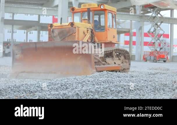 Bulldozer levels the soil. Bulldozer tearing rubble on the ground. Big ...
