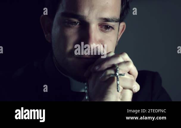 young priest praying and crying and searching for god: troubled and sad ...