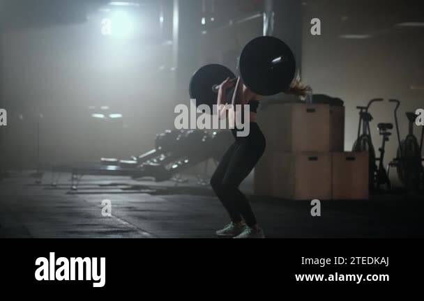 Female bodybuilder doing exercise with weights in gym. a female ...