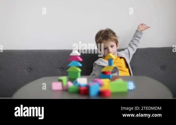 Little boy building constructor tower of colorful wooden blocks at home ...