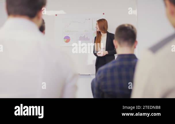 office woman presenting to the team taking notes in the boardroom ...