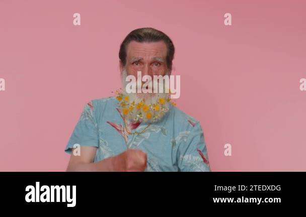 Mime senior man with flowers in gray-haired beard pulling an imaginary ...