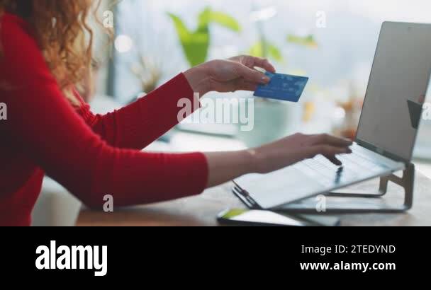Young business woman holding a credit card and using a laptop computer ...
